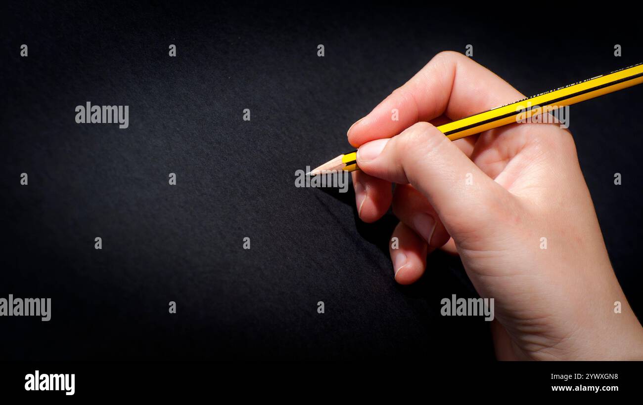 Human hand holding pencil and draws Stock Photo - Alamy