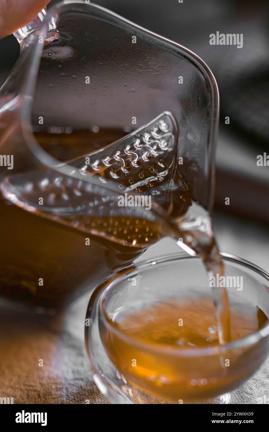 Pouring Tea from a Glass Pot into a Small Elegant Cup for a Refreshing ...