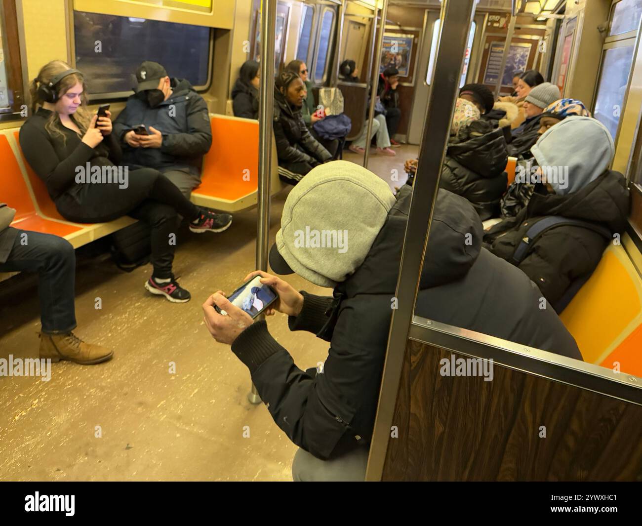 People on their phones riding a New York City subway train in Brooklyn ...