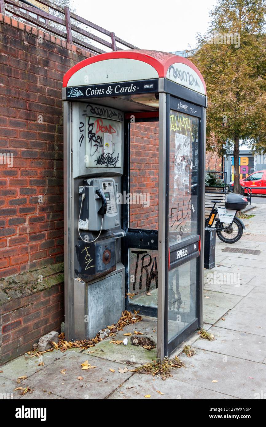 A BT public telephone box, covered with graffiti, in Junction Road ...