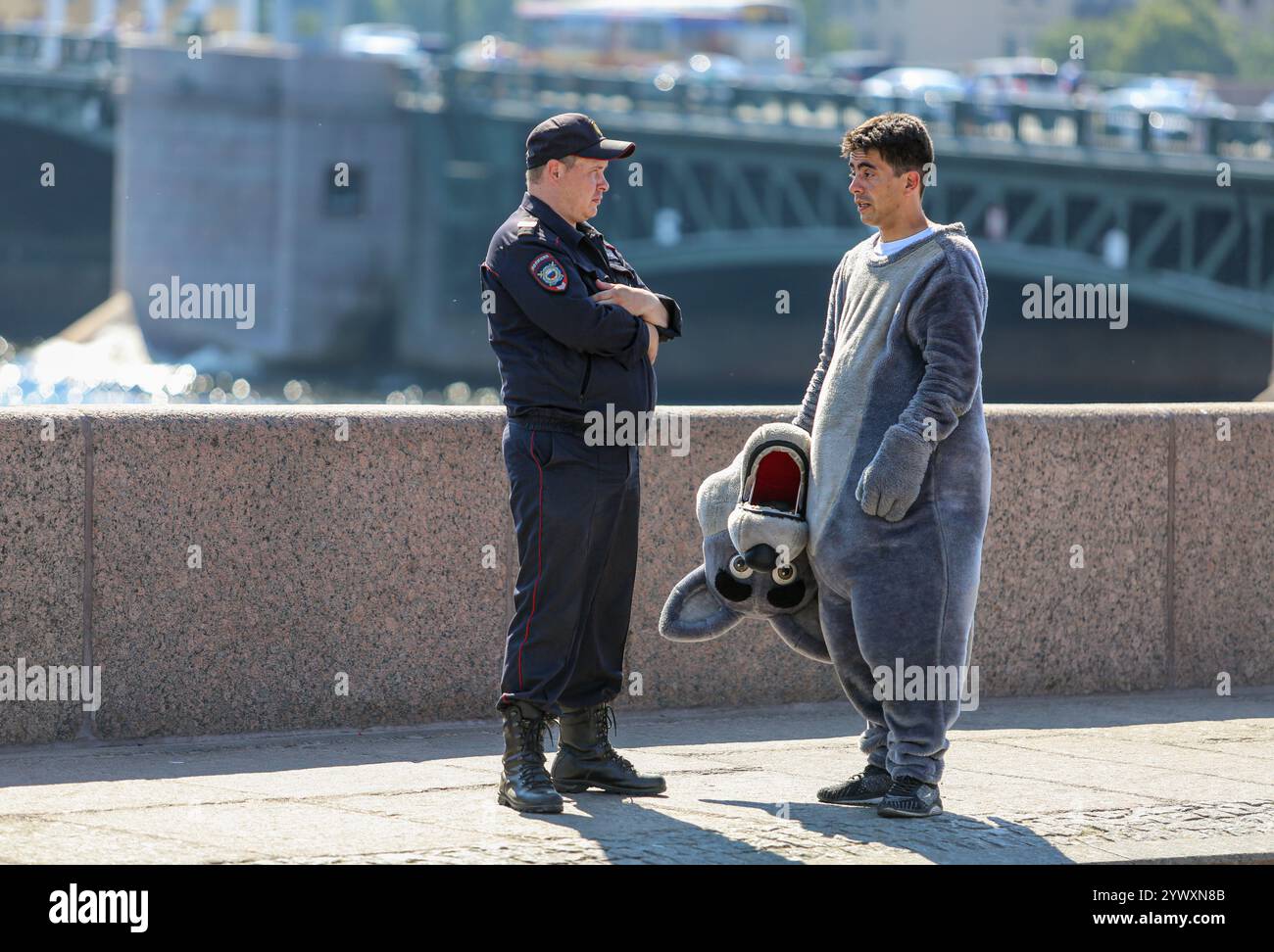 A Russian police officer chats with an embarrassed-looking man dressed ...