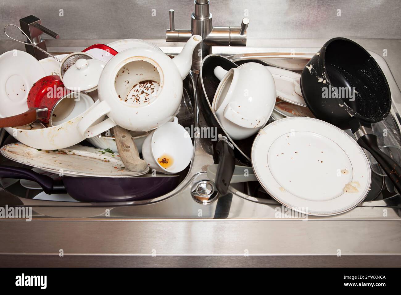 Pile of dirty dishes on sink in the kitchen Stock Photo - Alamy