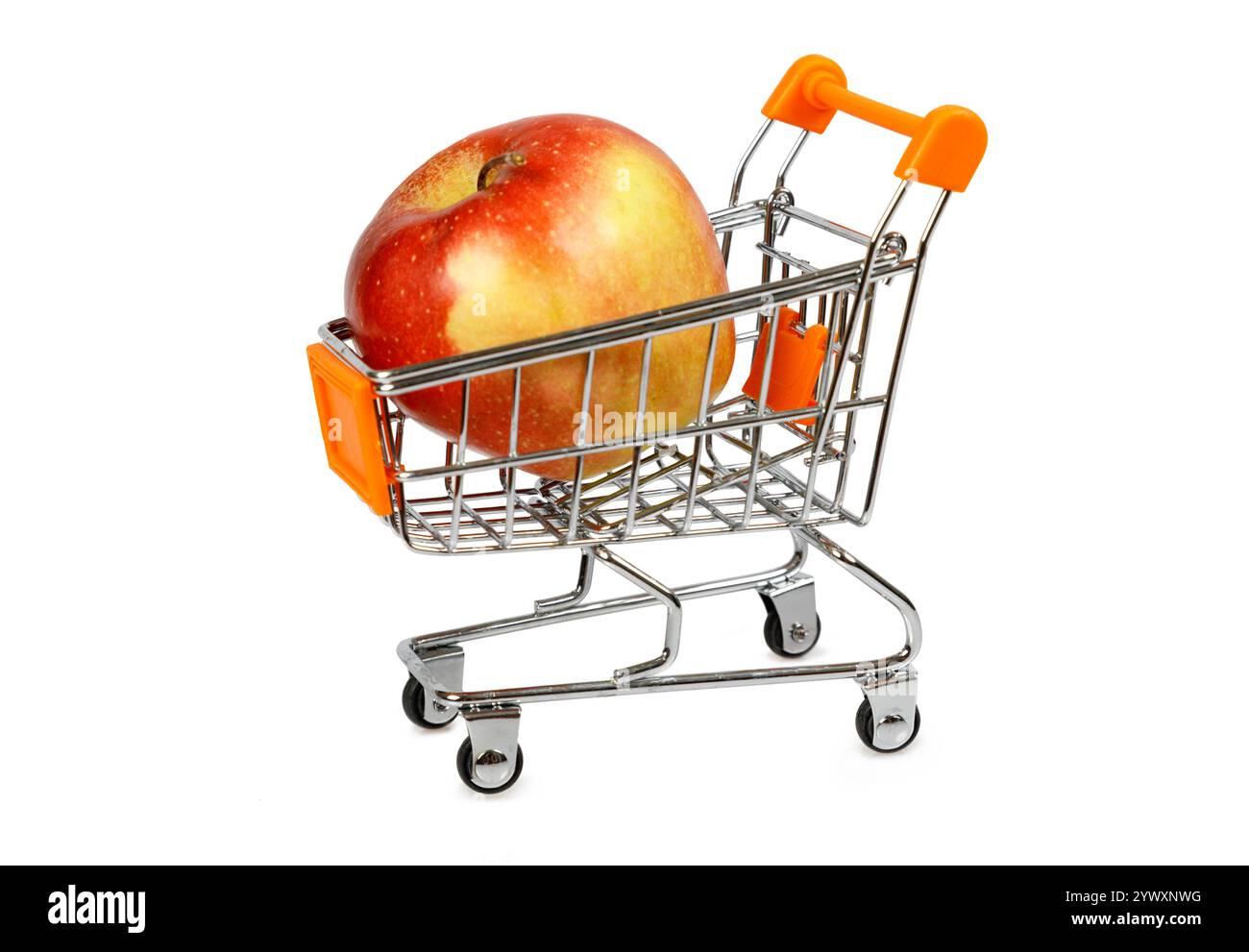 A red apple lies in a toy shopping cart isolated on a white background ...