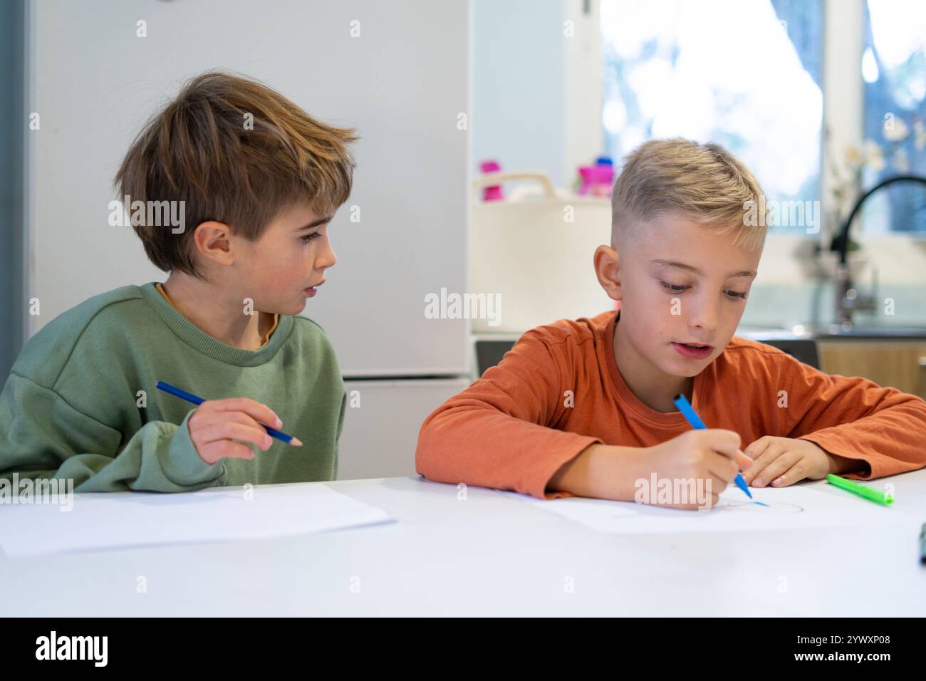 Two brothers are enjoying their time together drawing with colored ...