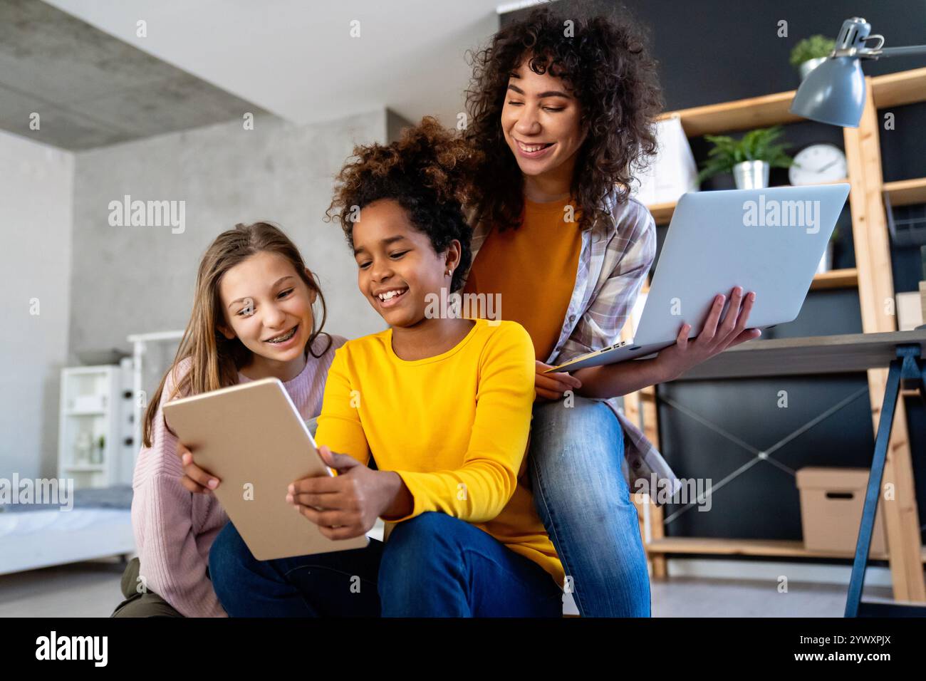 Happy multiethnic teenagers holding technology gadgets using digital ...