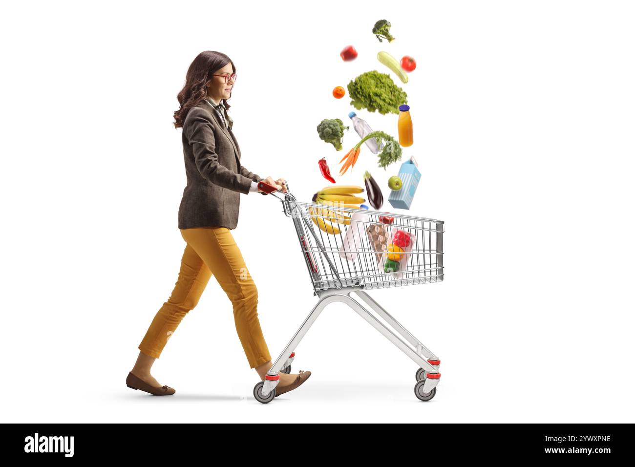 Full length profile shot of a young woman walking with a shopping cart ...