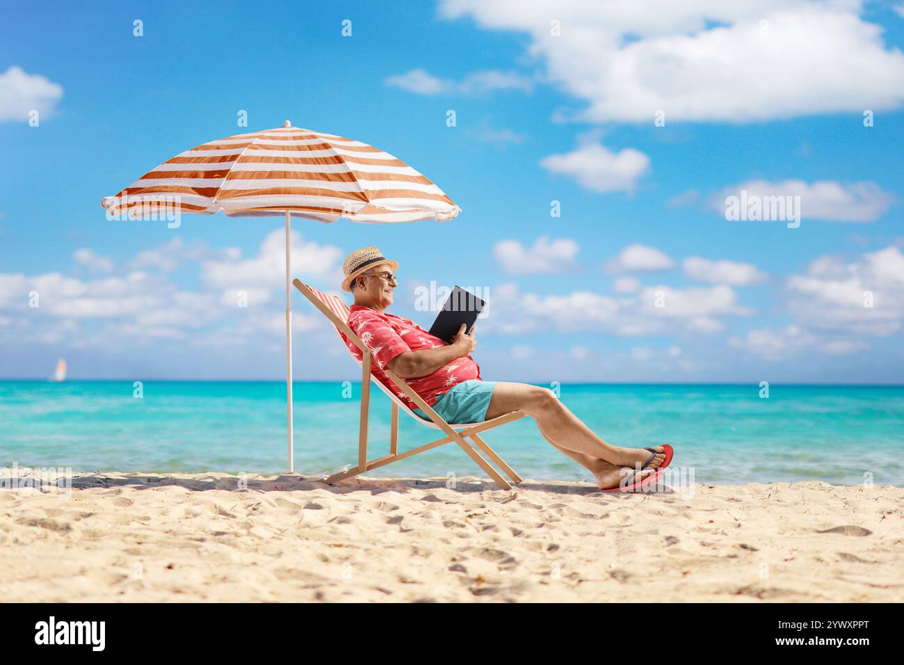 Tourist reading a book and sitting in a beach chair by the sea Stock ...