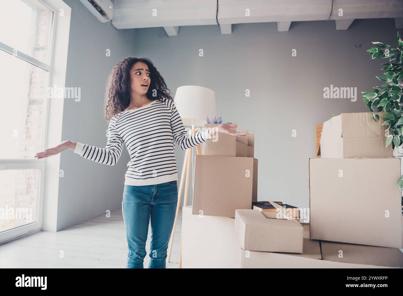Portrait of nice young girl shrug shoulders pile stack box package ...