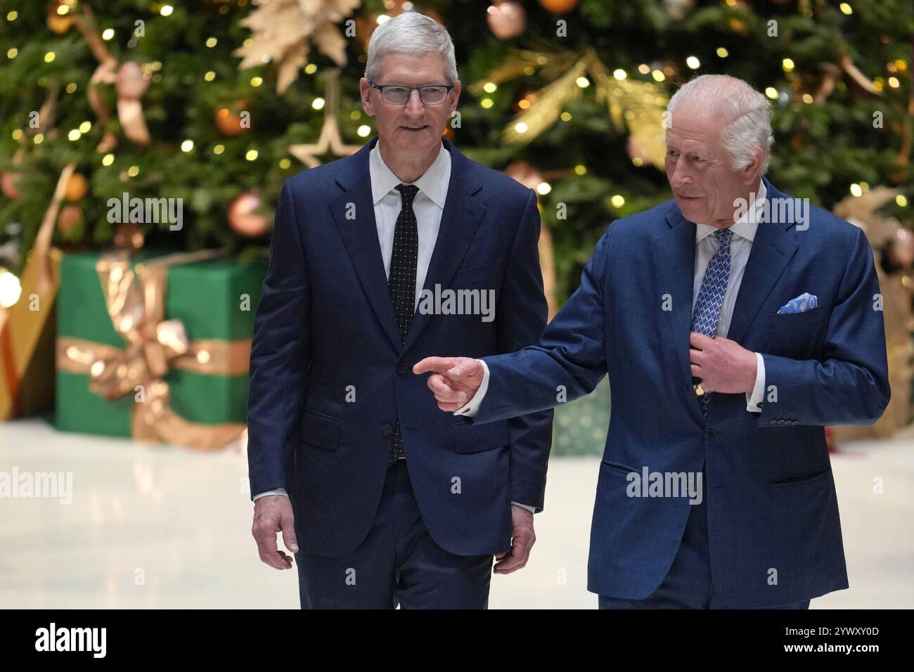 Britain's King Charles III, right, gestures as he walks with Apple CEO ...
