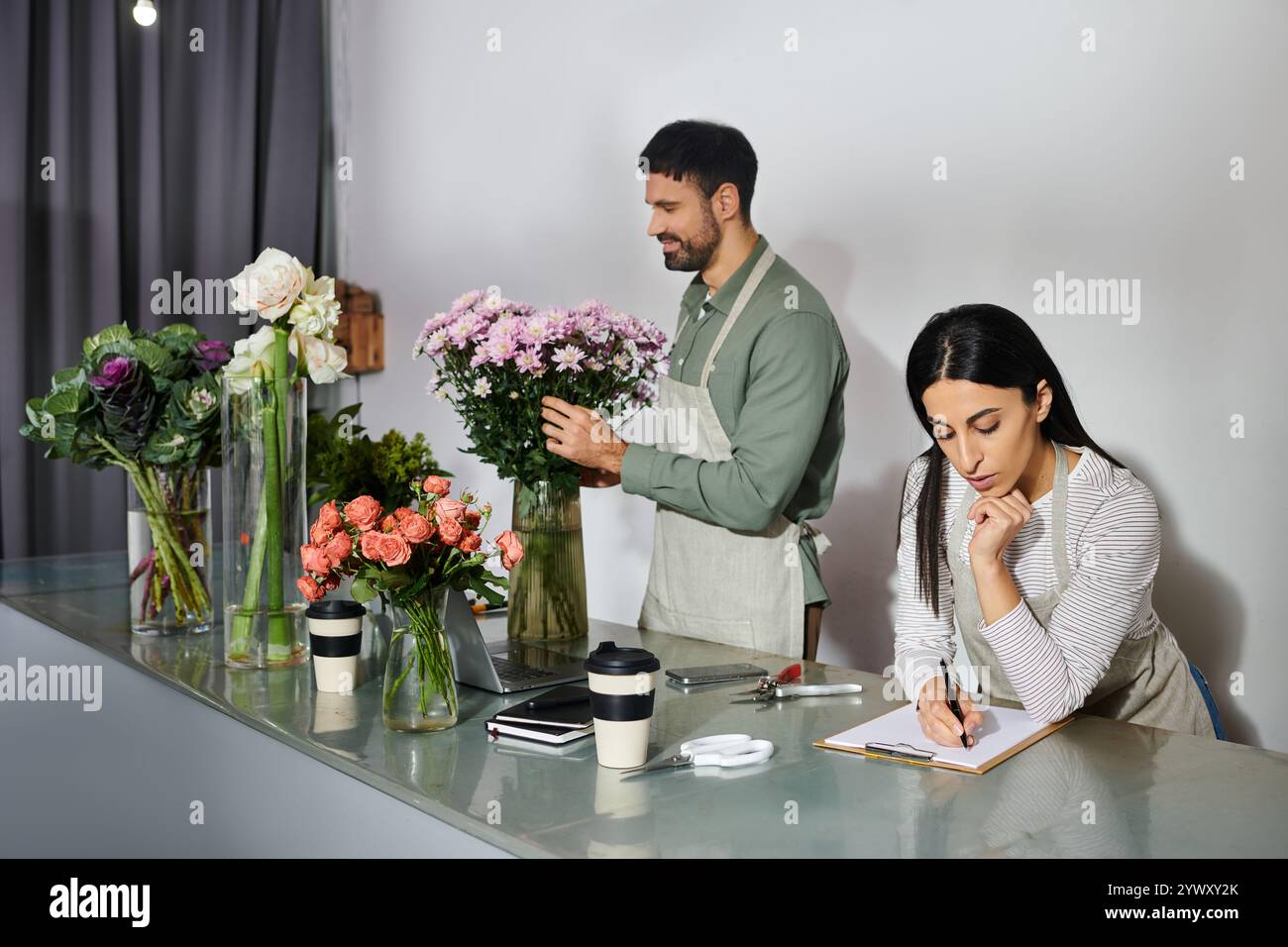 Two florists work side by side in their shop, crafting floral ...