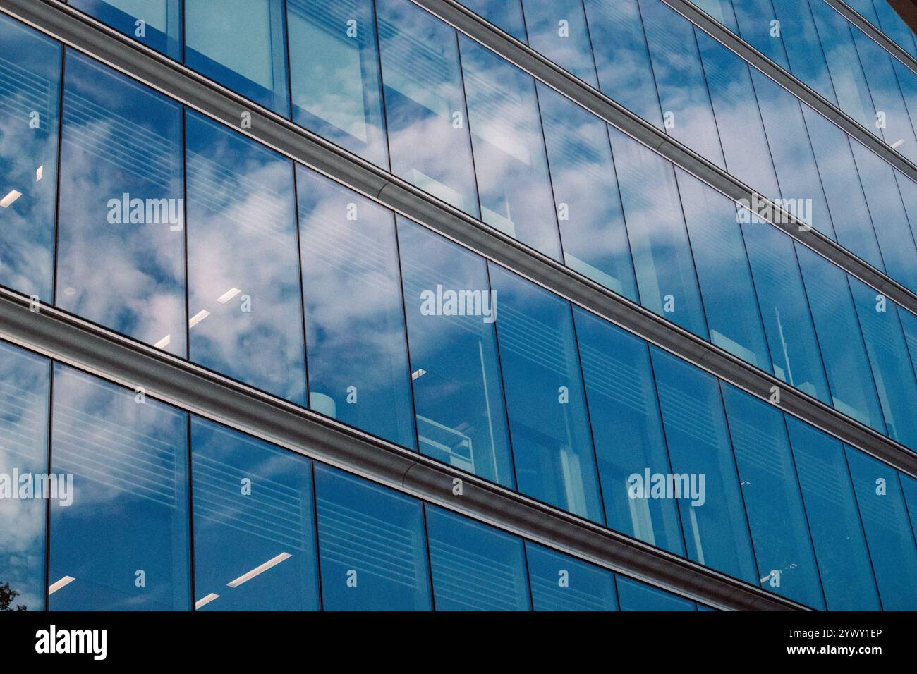 Modern office building glass facade with sky reflection in the windows ...