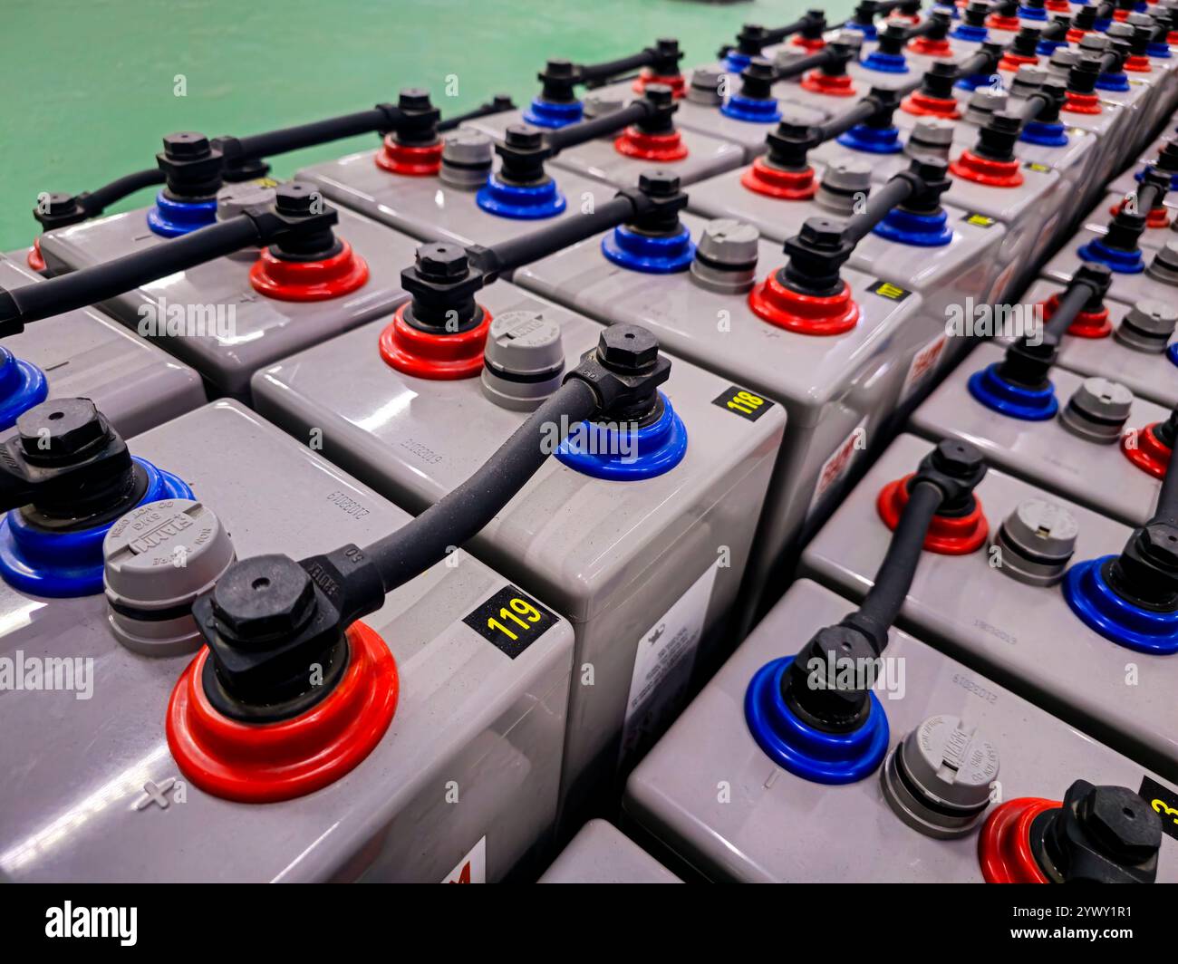 A row of batteries with red, blue, and white caps. The batteries are ...