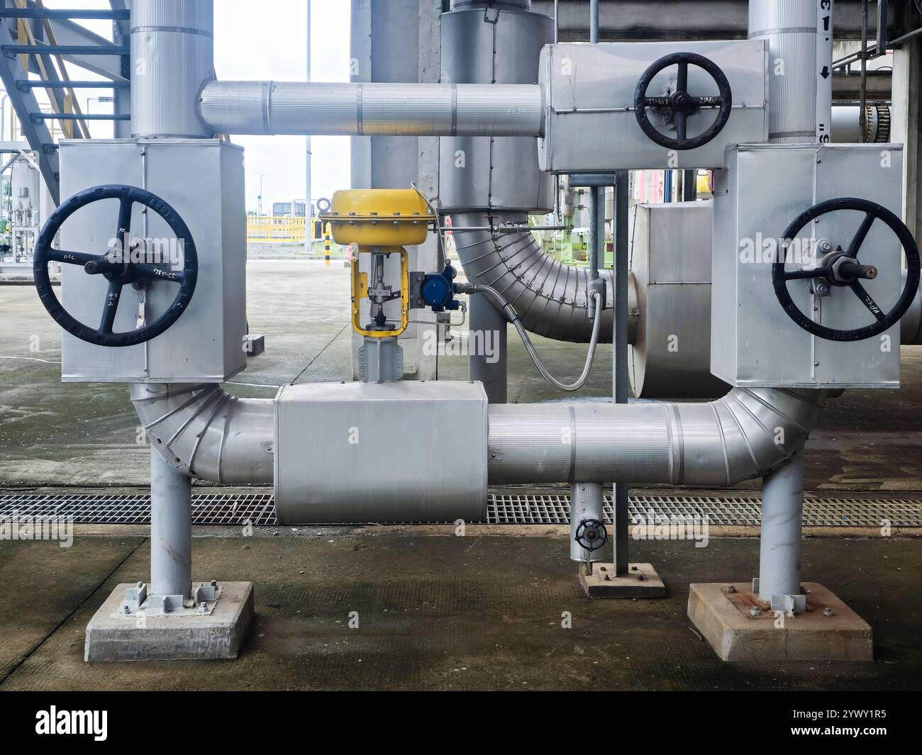 A pipe with two valves on it. One of the valves is yellow. The other is ...