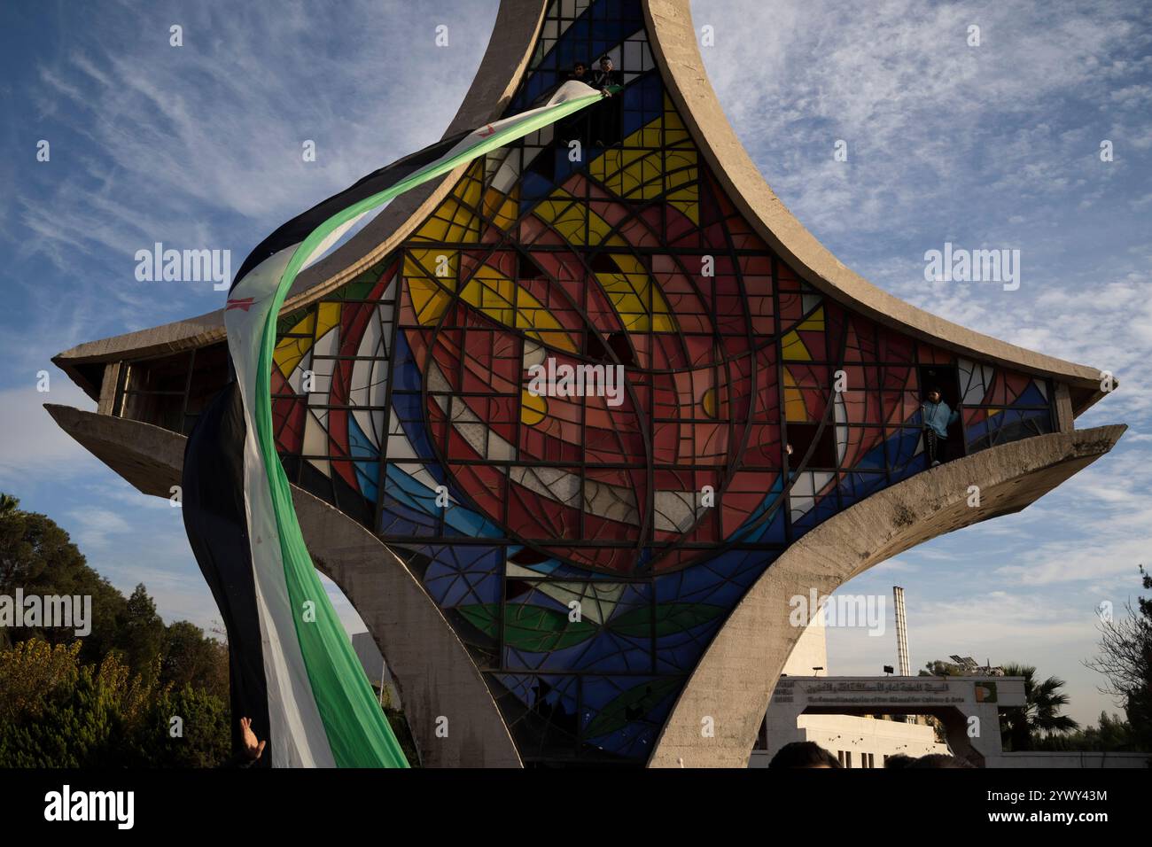 People hold a giant Syrian opposition flag at the Damascene Sword ...
