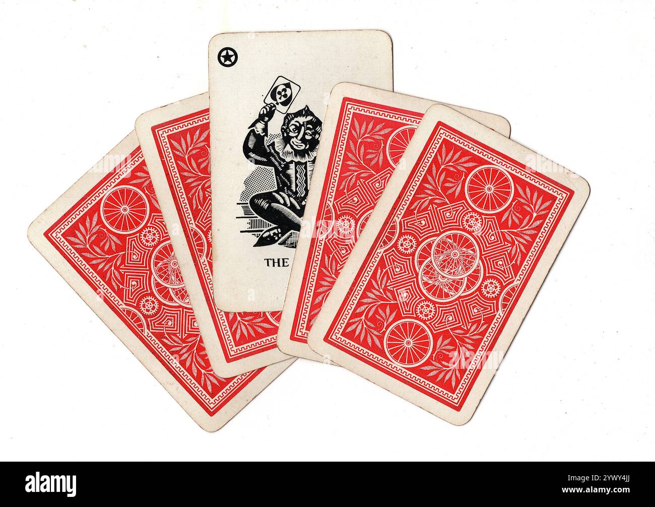 A hand of vintage playing card backs with the joker revealed on a white ...