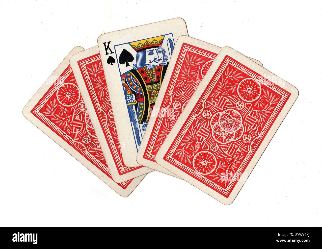 A hand of vintage playing card backs with the king of spades revealed ...