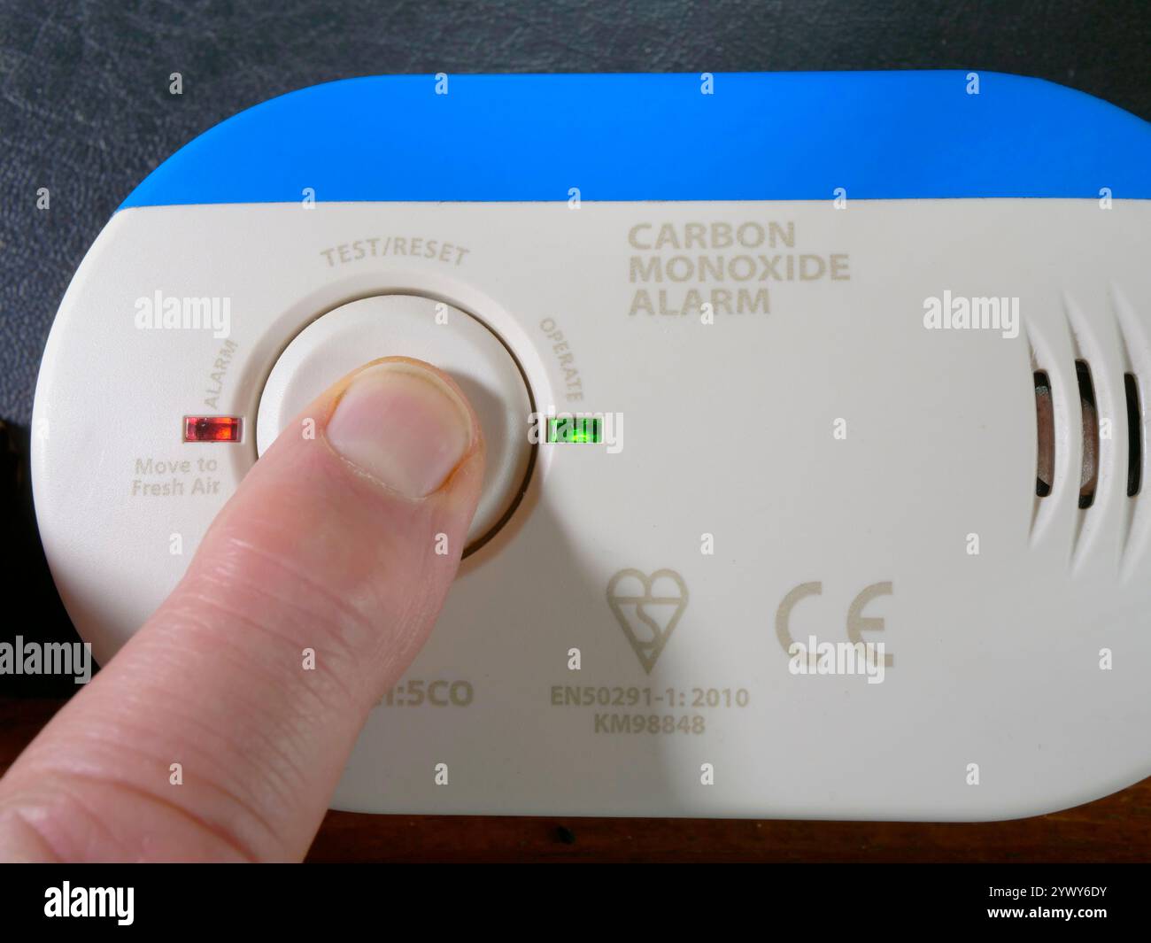 Closeup of a finger tip pressing the button to test the operation of a ...
