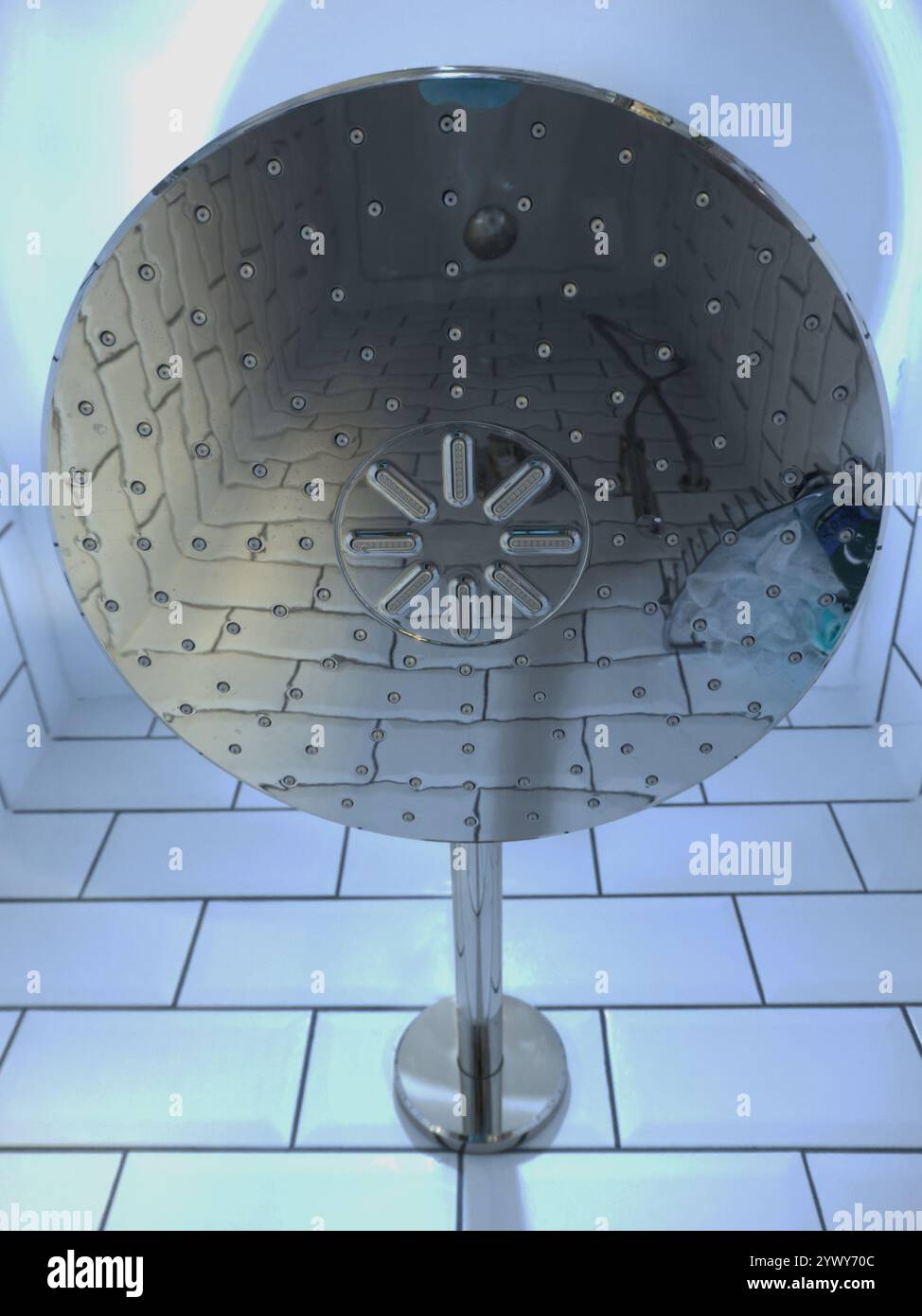 Closeup of the underside of a large modern shower head, which shows the ...
