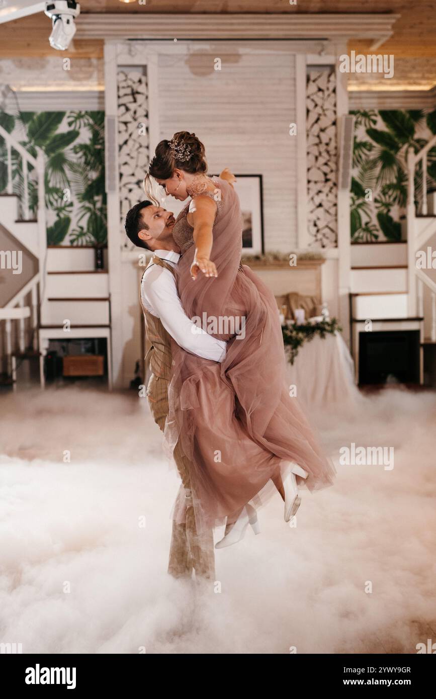 the first dance of the bride and groom inside a restaurant with heavy ...
