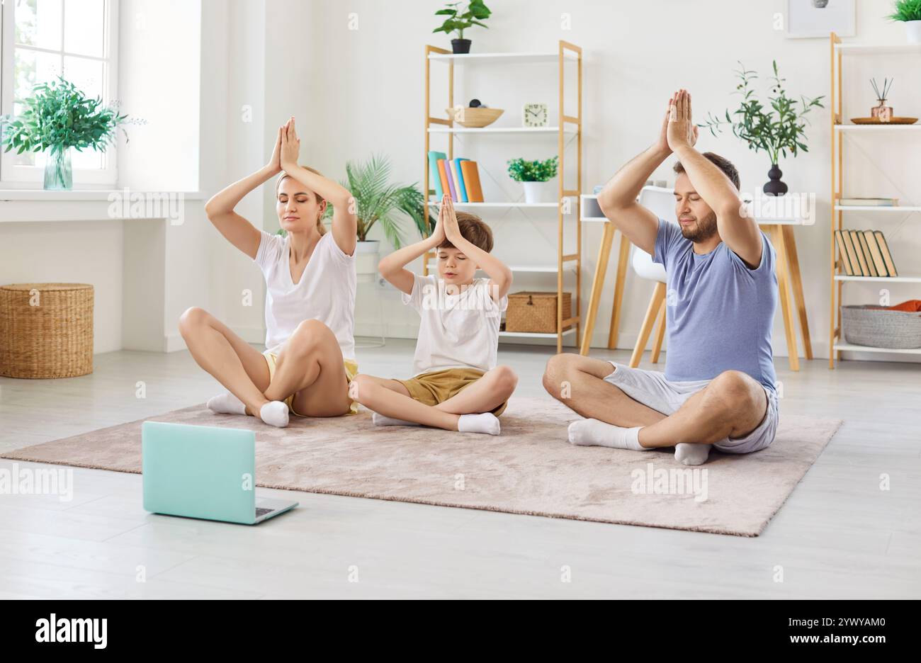Happy Family Meditating During Yoga Session At Home Using Laptop Stock ...