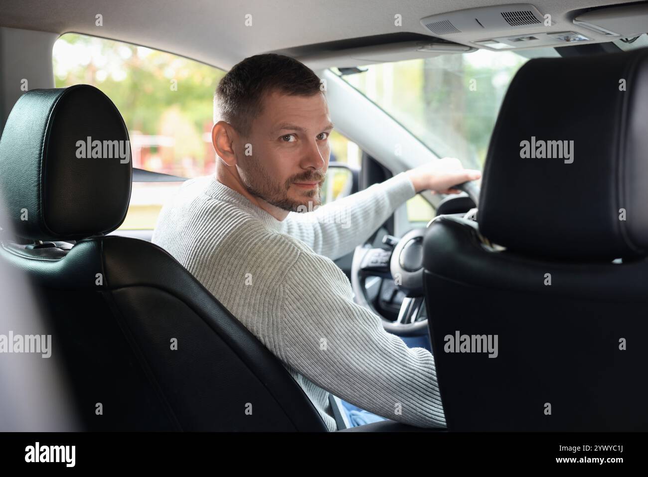 Man behind steering wheel of modern car Stock Photo - Alamy