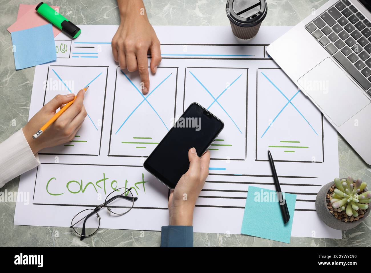 Developing UI design. Designers creating website wireframe on paper at ...