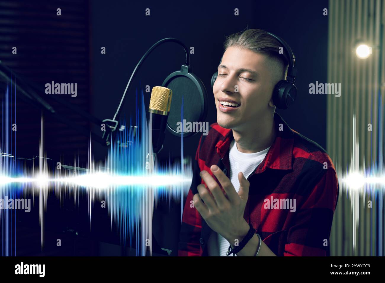 Vocalist with headphones singing into microphone in professional record ...