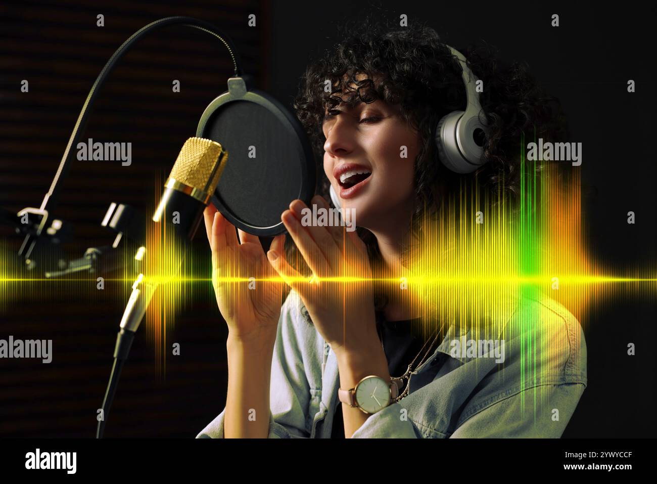 Vocalist with headphones singing into microphone in professional record ...