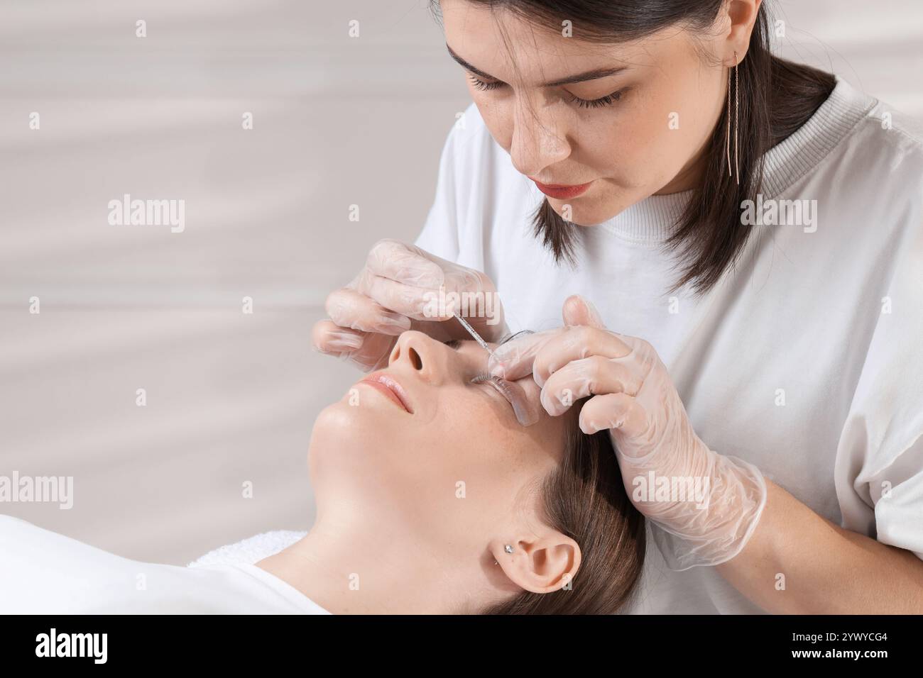 Eyelash lamination procedure. Esthetician sticking woman's lashes to ...