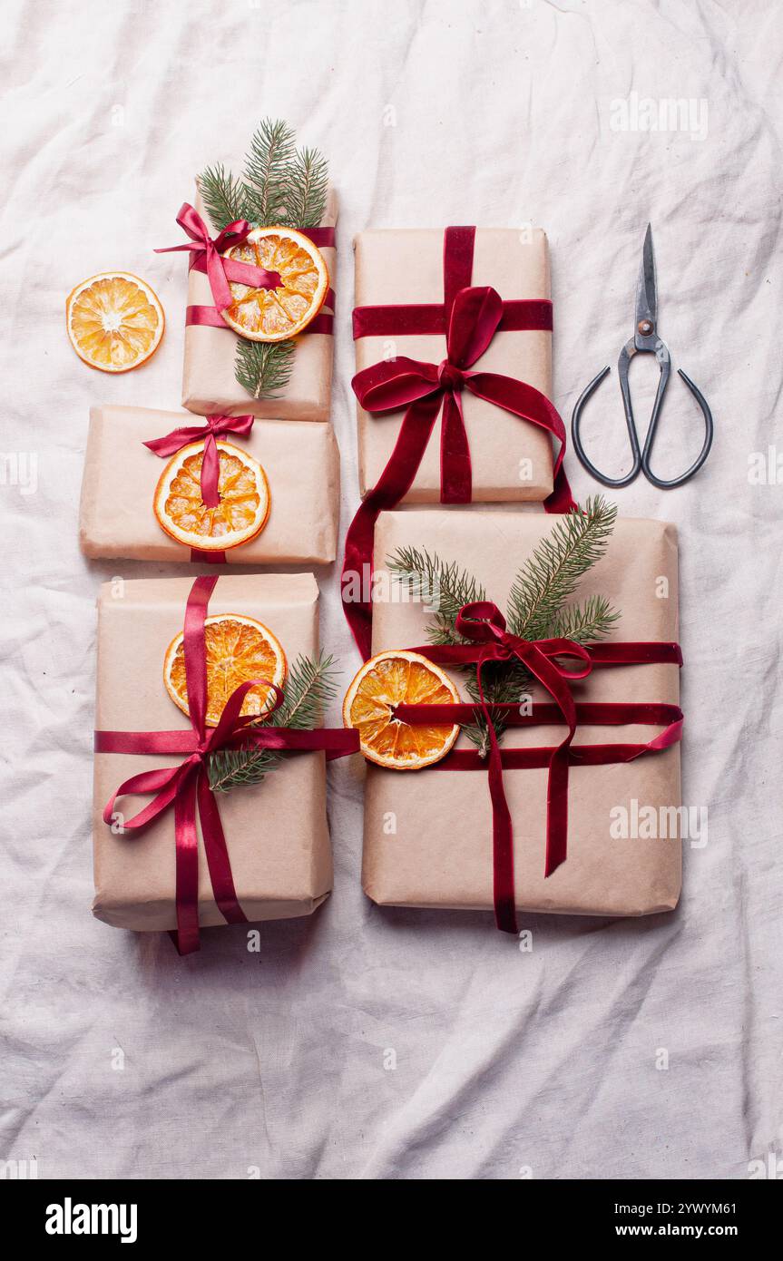 Wrapped gifts with dried orange and velvet pine branches and bows on ...