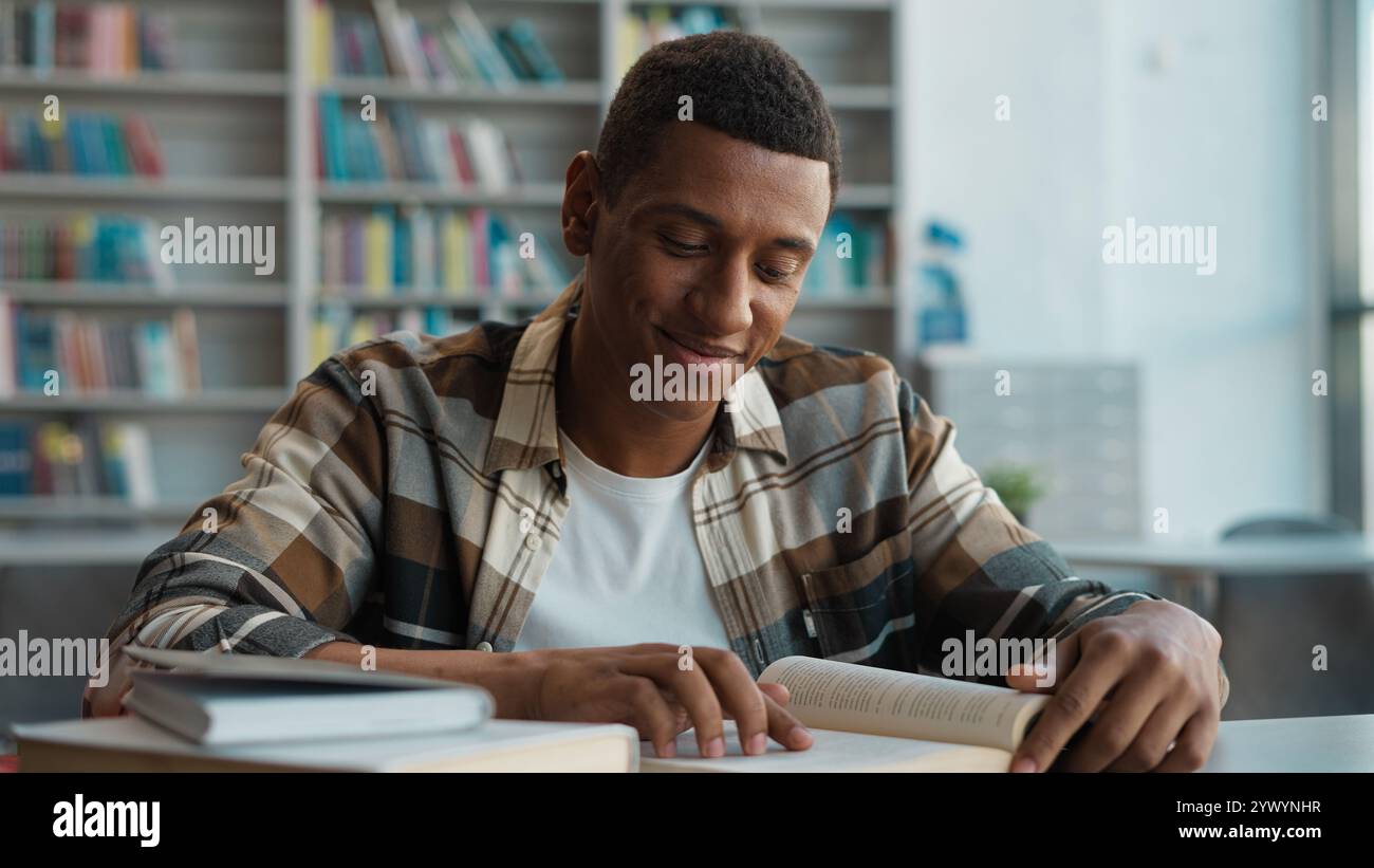 African American man bookworm reader library reading book smiling ...