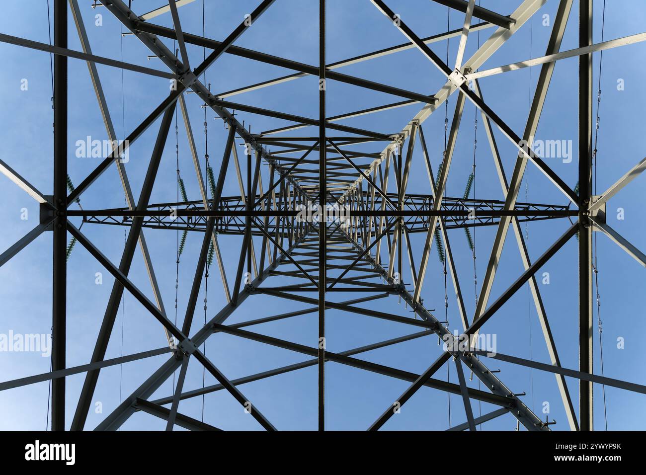 High voltage pylons against a slightly clouded blue sky Stock Photo - Alamy