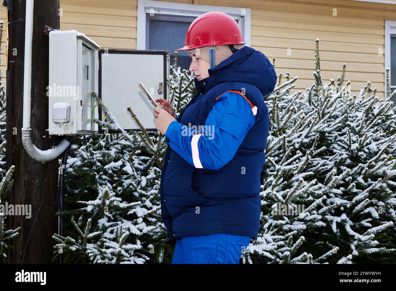Utility employee checks electric meter of countryside customers Stock ...