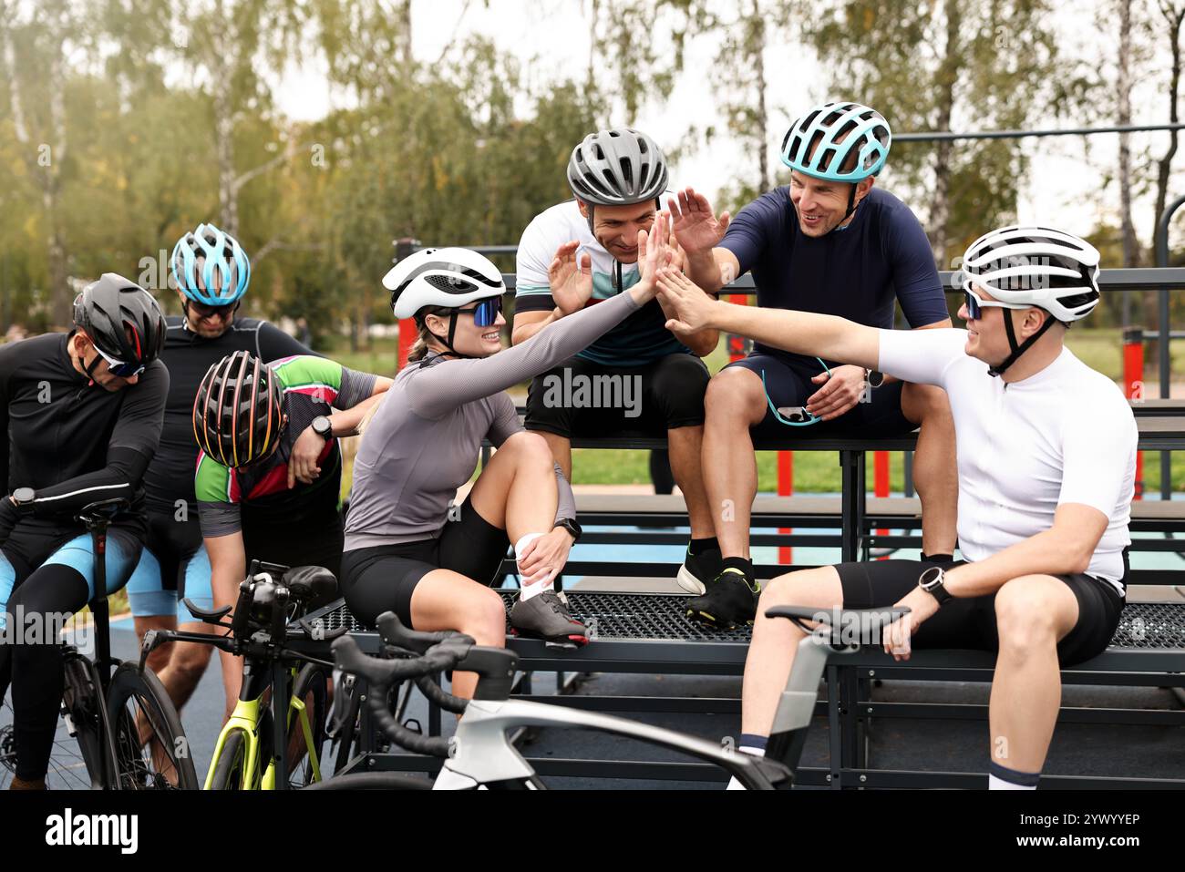 Group of athletic people with helmets and bicycles spending time ...