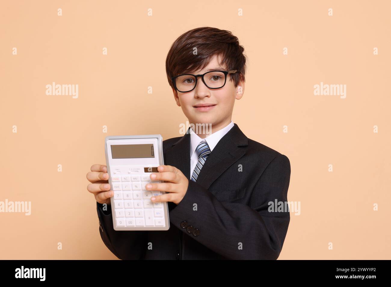 Boy with calculator pretending to be accountant on beige background ...