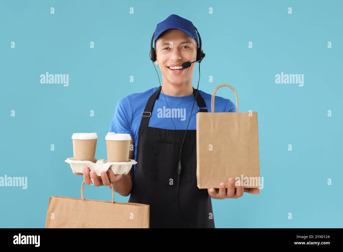 Fast-food worker with paper bags and cups on light blue background ...