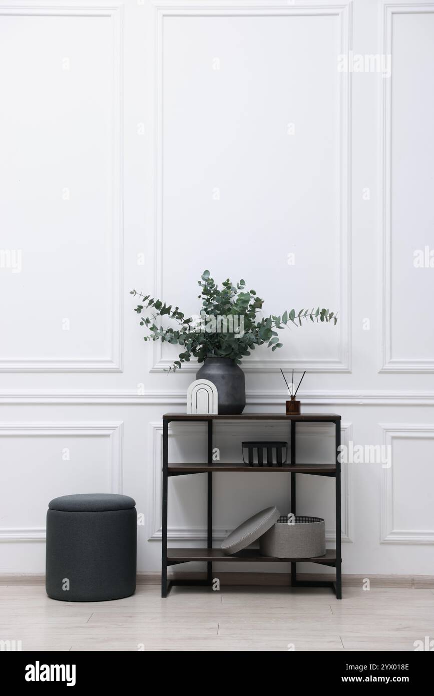 Console table with decor and pouf in room. Interior design Stock Photo ...