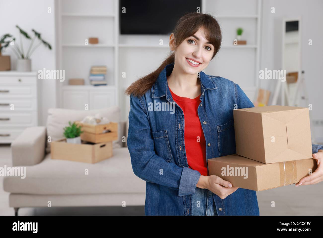 Happy woman with moving boxes in new apartment. Housewarming party ...