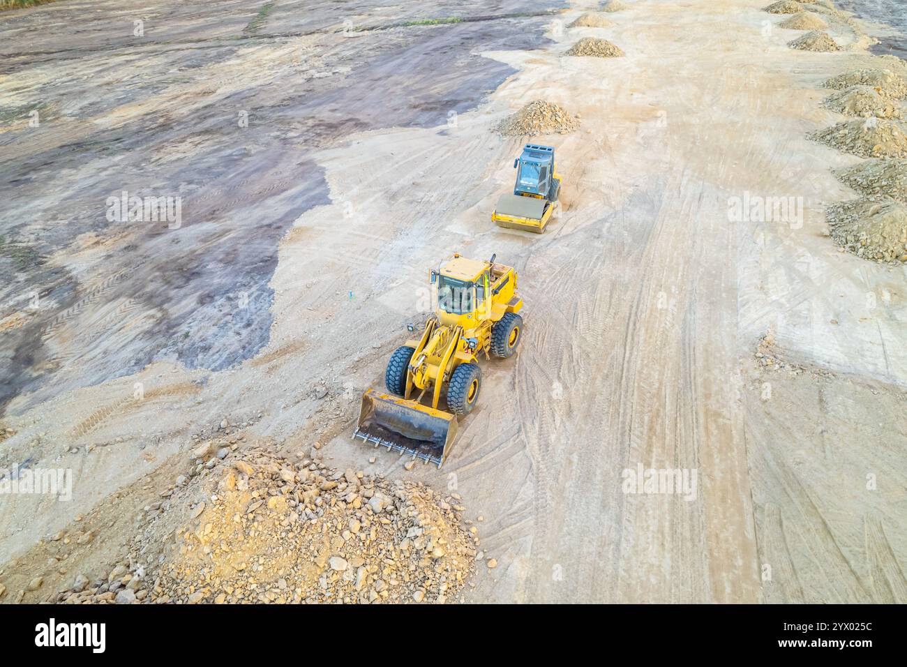 heavy machinery on a construction site, a bulldozer and a steamroller ...