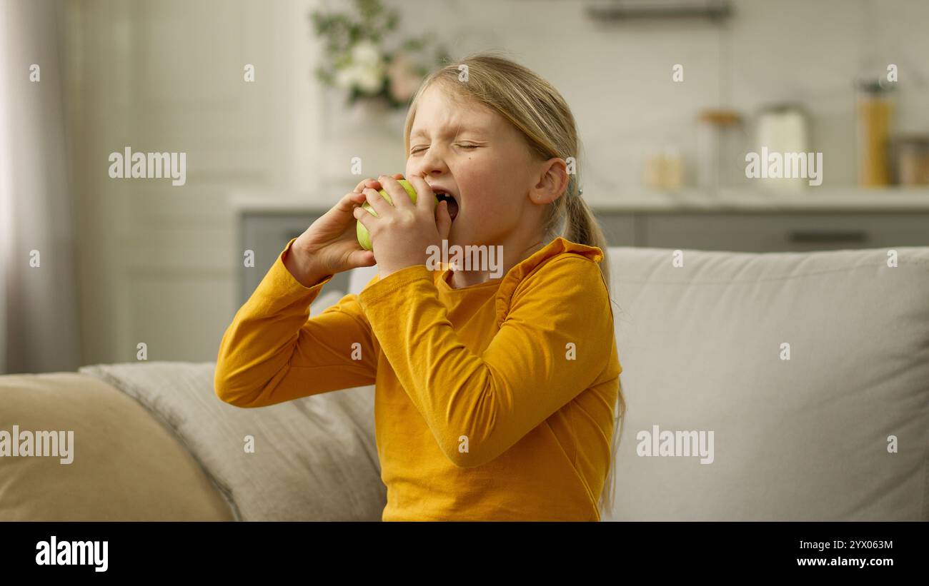 Little girl home biting eat apple food nutrition grabbing tooth pain ...