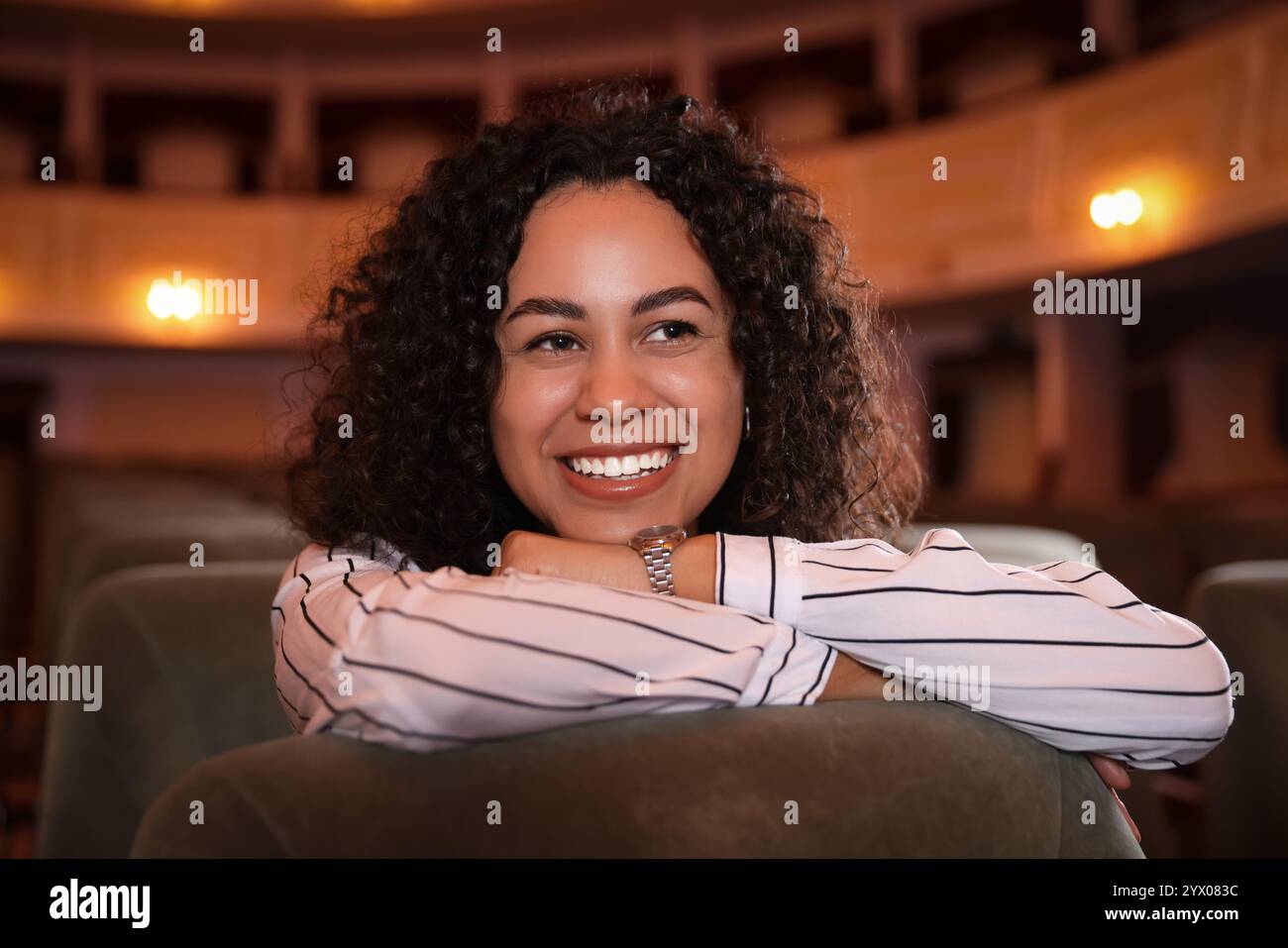 Happy woman watching theatrical performance in theatre Stock Photo - Alamy
