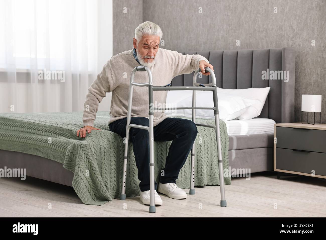 Senior man with walking frame on bed at home Stock Photo - Alamy