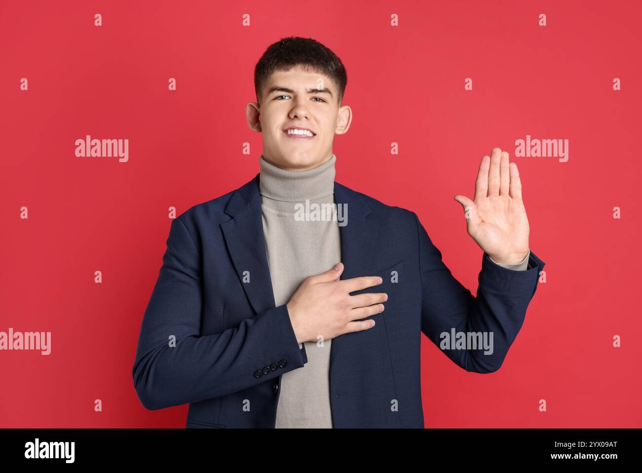 Man making promise with raised hand on red background. Oath gesture ...