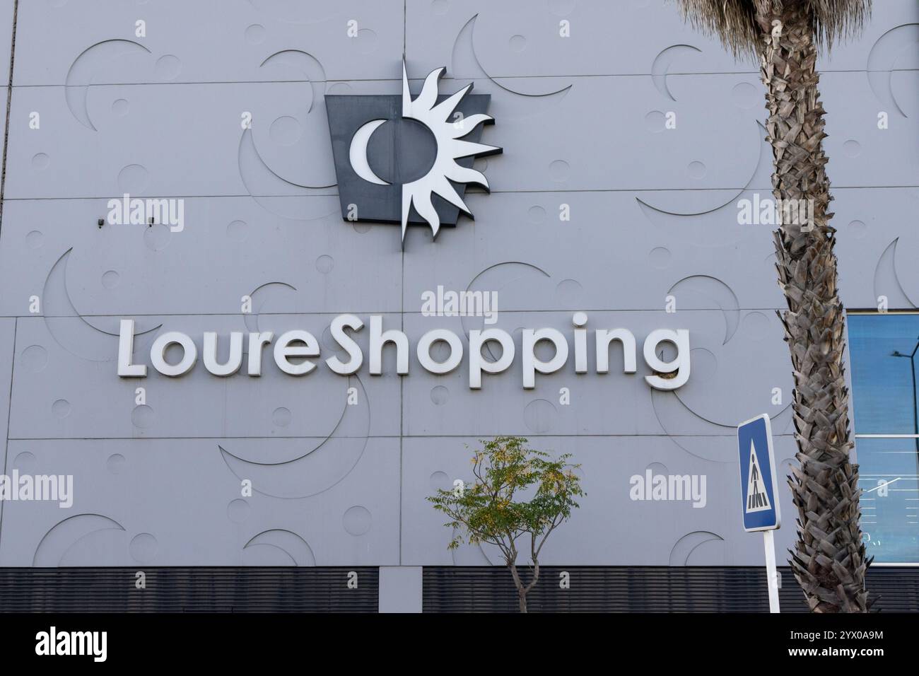 Loure shopping center logo with sun and moon design on modern building ...