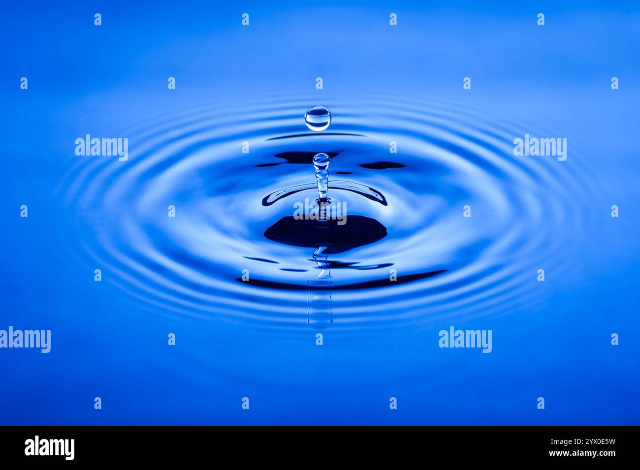 Waves of water caused by the falling droplets with blue lighting Stock ...
