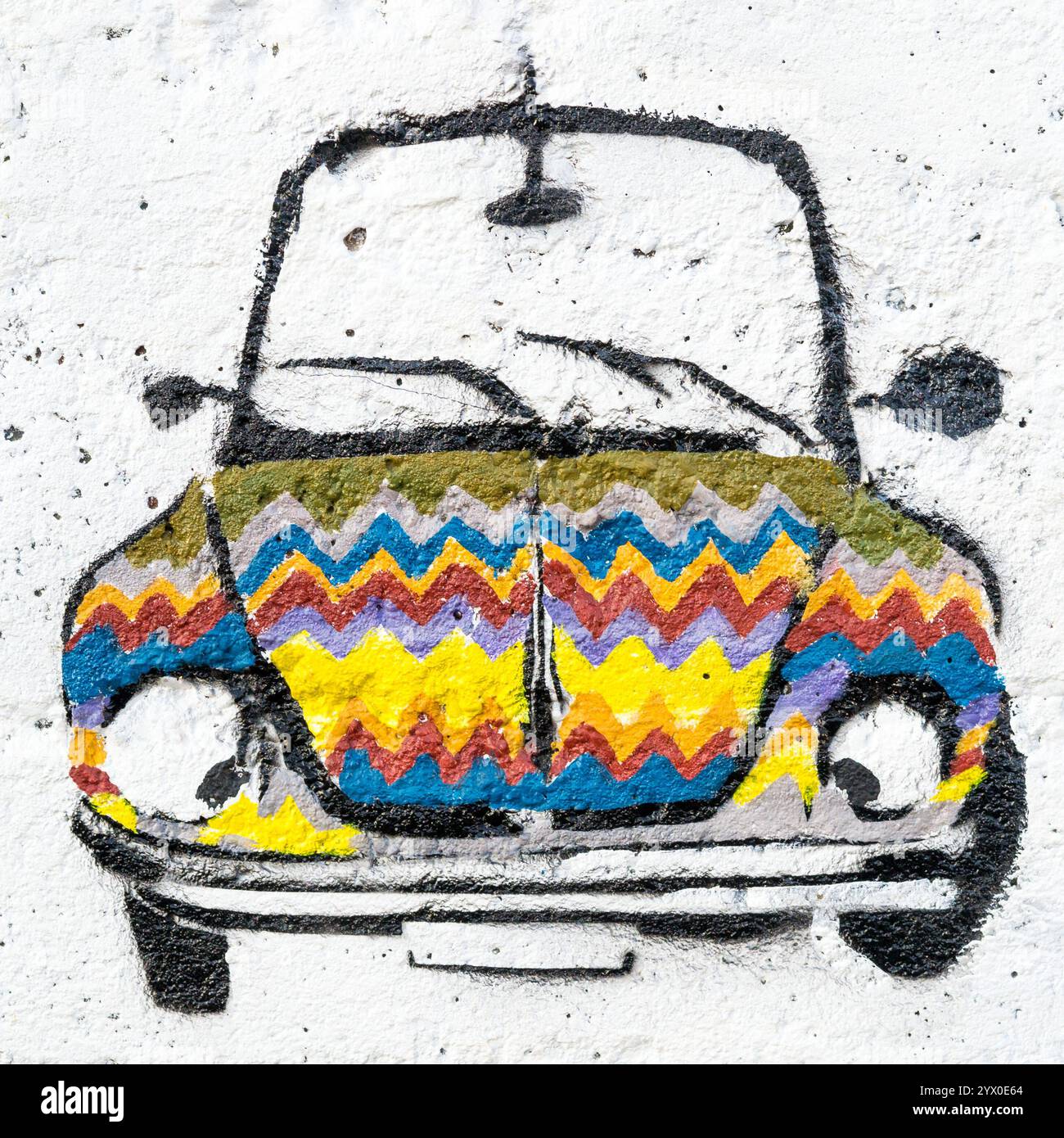 Street graffiti displays colorful and retro car on white concrete wall ...