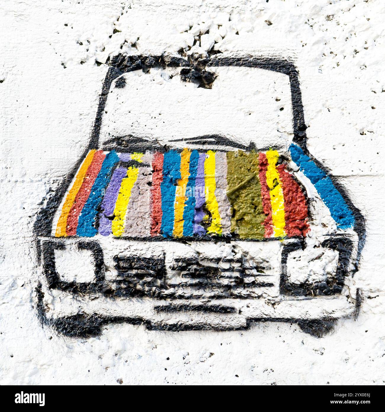 Street graffiti displays colorful and retro car on white concrete wall ...
