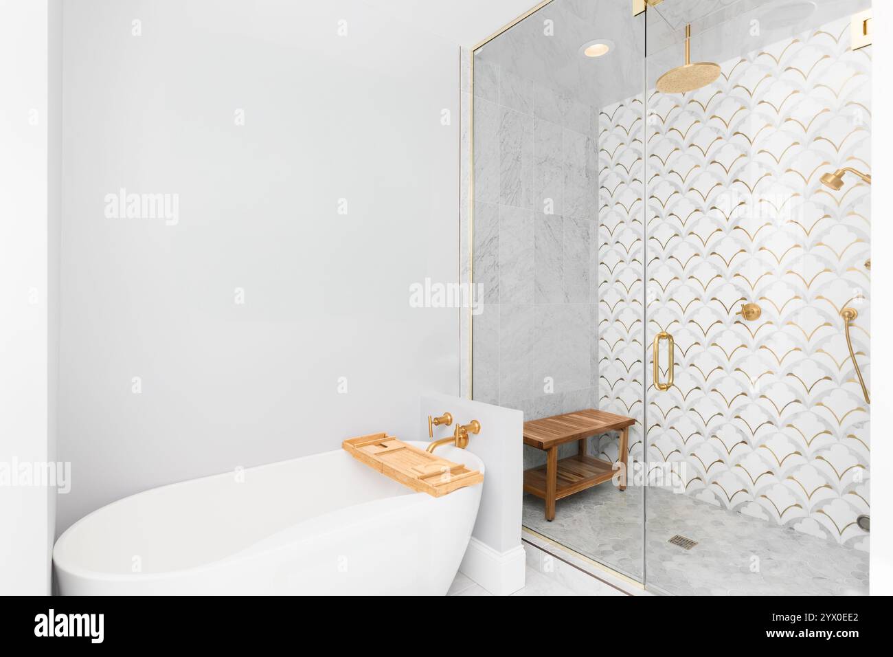 A bathroom with a freestanding soaking tub with a gold faucet and a ...
