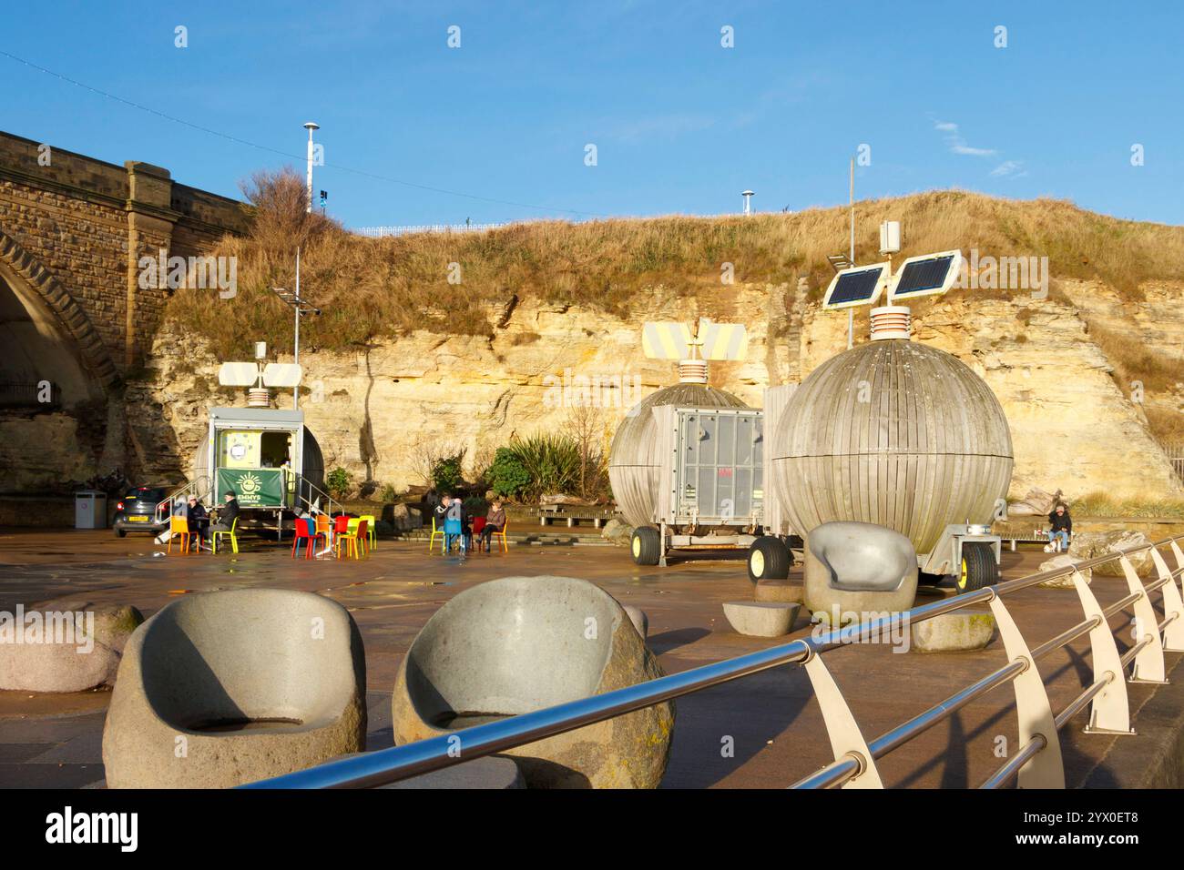 spherical wooden pod structures with cafe and stage at event space near ...