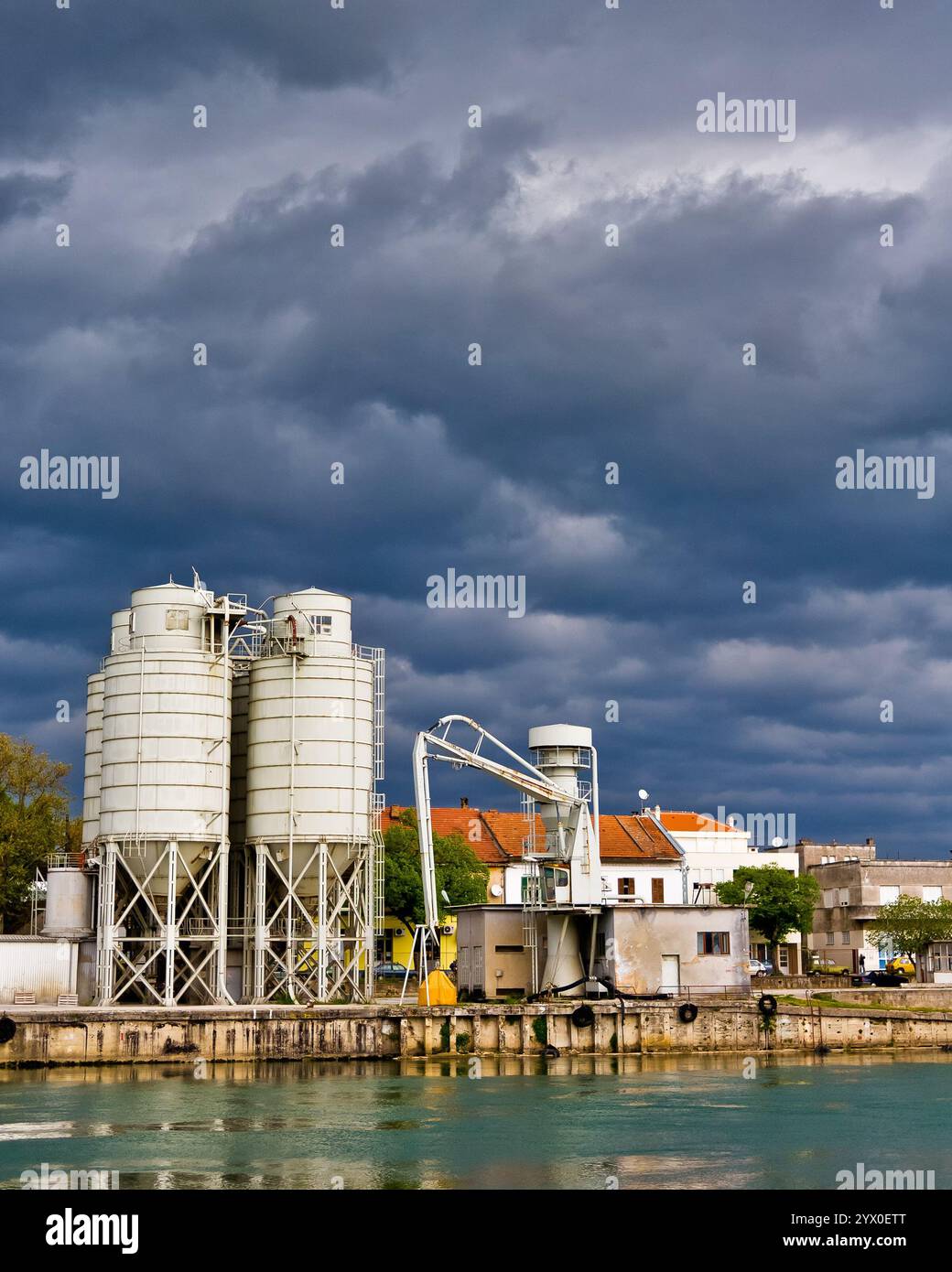 Silos for storage in the industrial river port with dramatic clouds ...